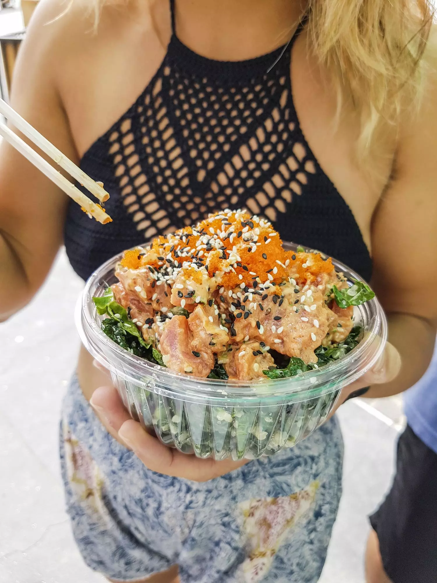 vrouw die op het punt staat een poke bowl te eten