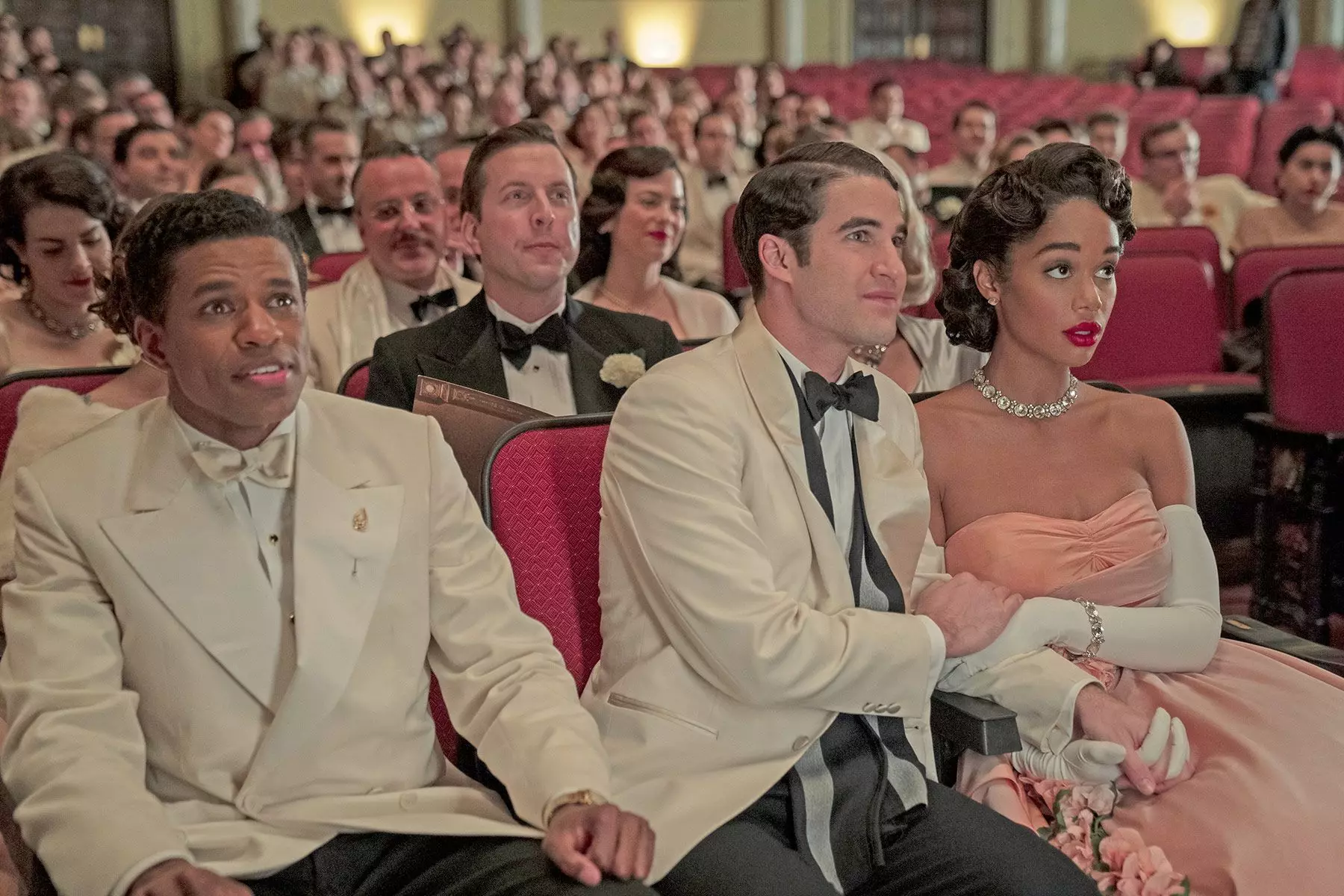 jeremy pope, darren criss û laura harrier di dîmenek ku merasîma oscarê di rêzefîlma netflix 'hollywood' de simule dike.