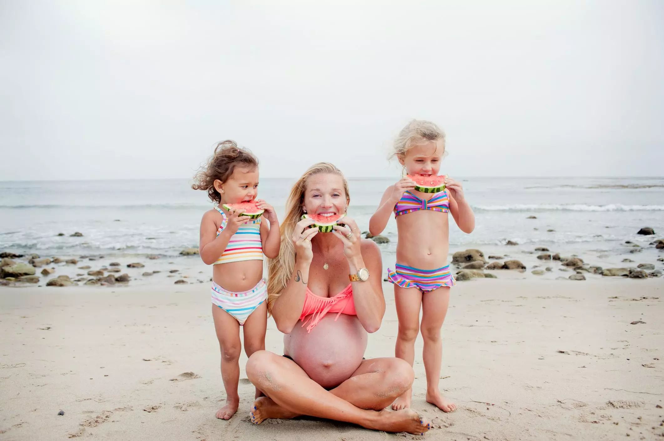sahilde kızları ile karpuz yiyen hamile kadın