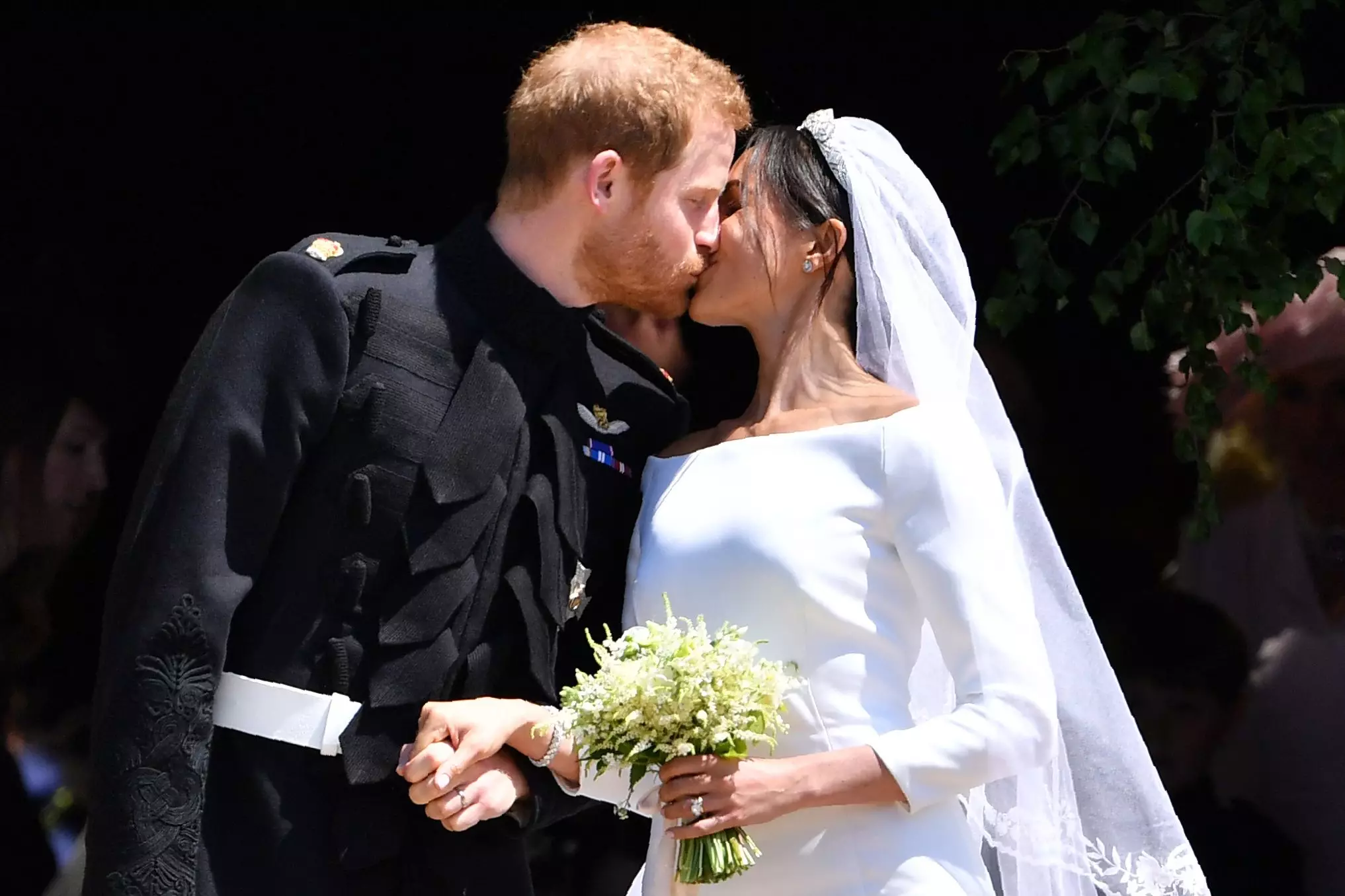 Megana Mārkla un princis Harijs skūpstās savā kāzu dienā