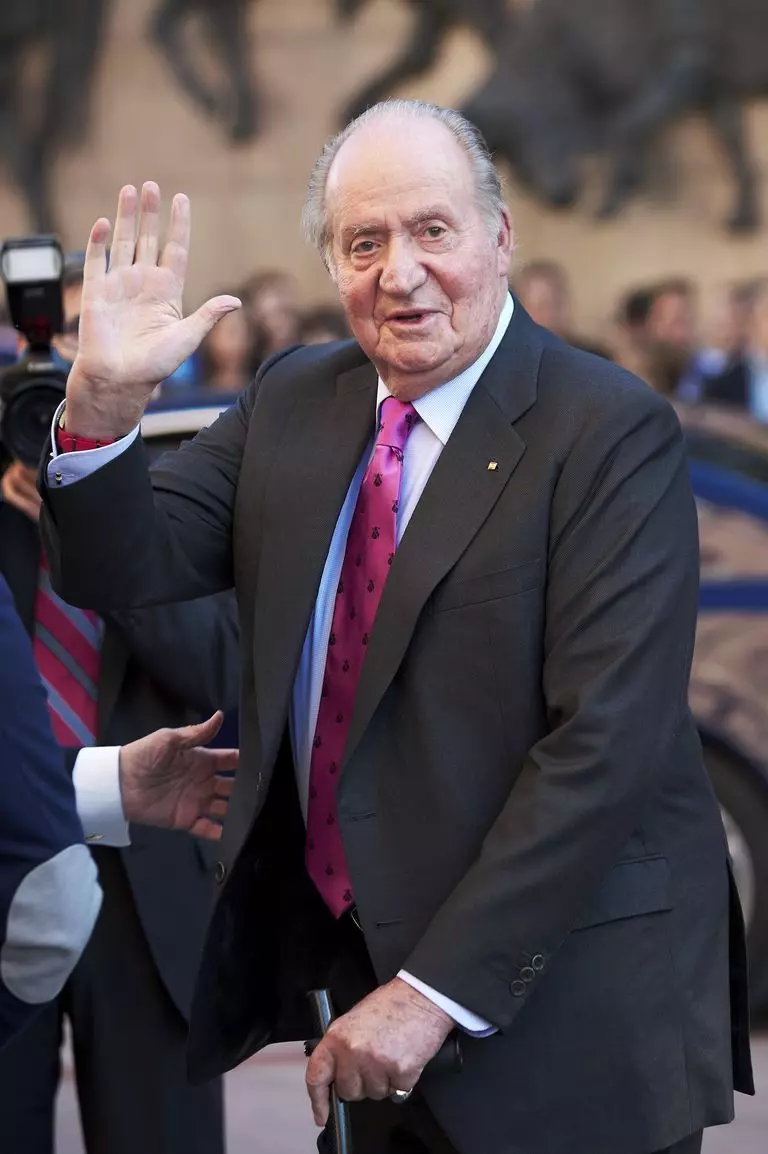 kong Juan Carlos vinker med hånden løftet på gaden