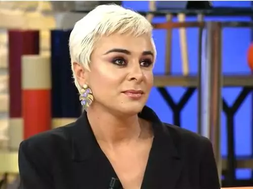 Ana Maria Aldon na televizijski plošči s kratkimi lasmi in resnim obrazom