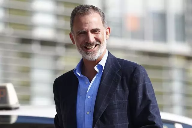 si king felipe nga nagpahiyom sa dalan nga adunay kamiseta ug jacket