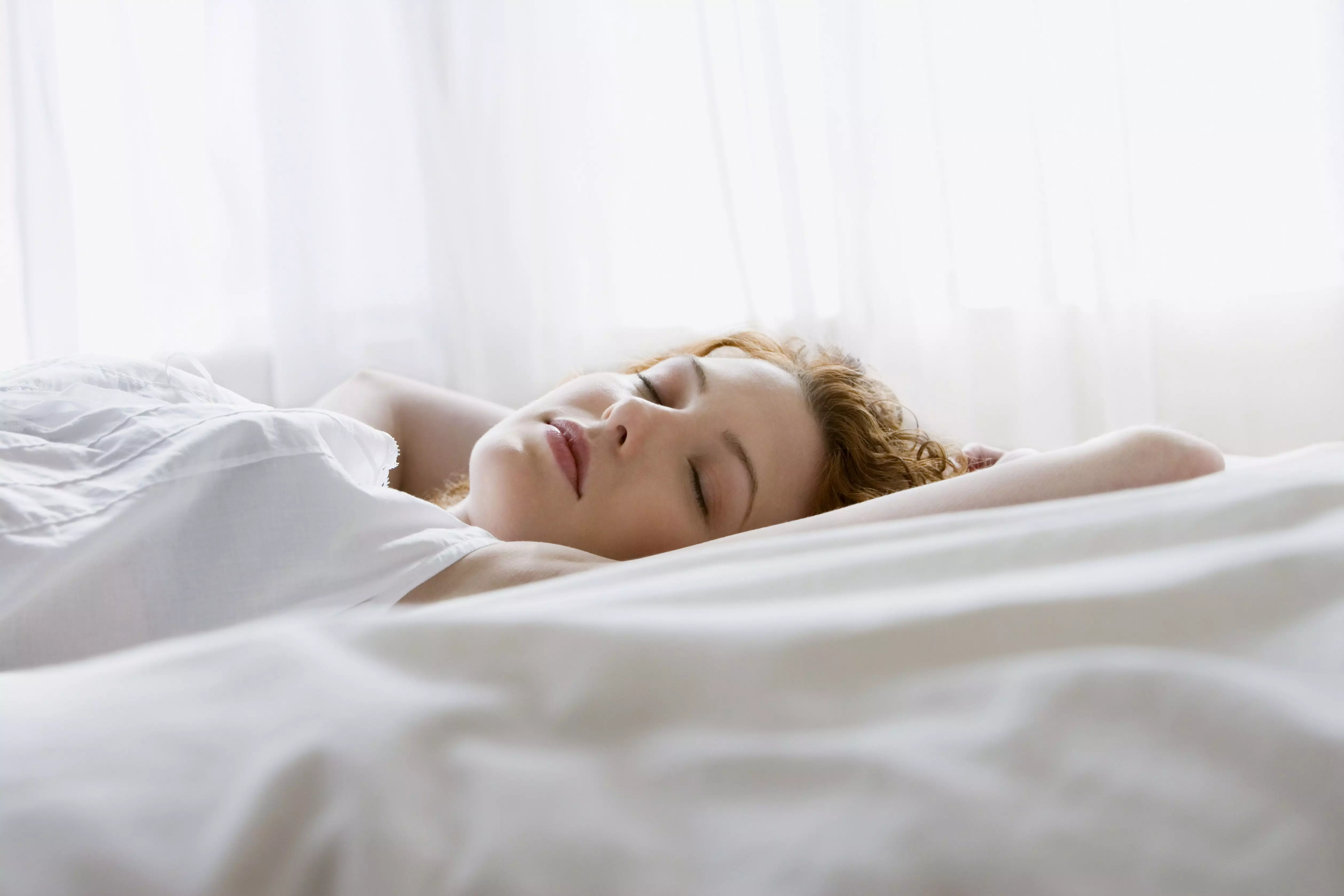 Young woman lying in bed