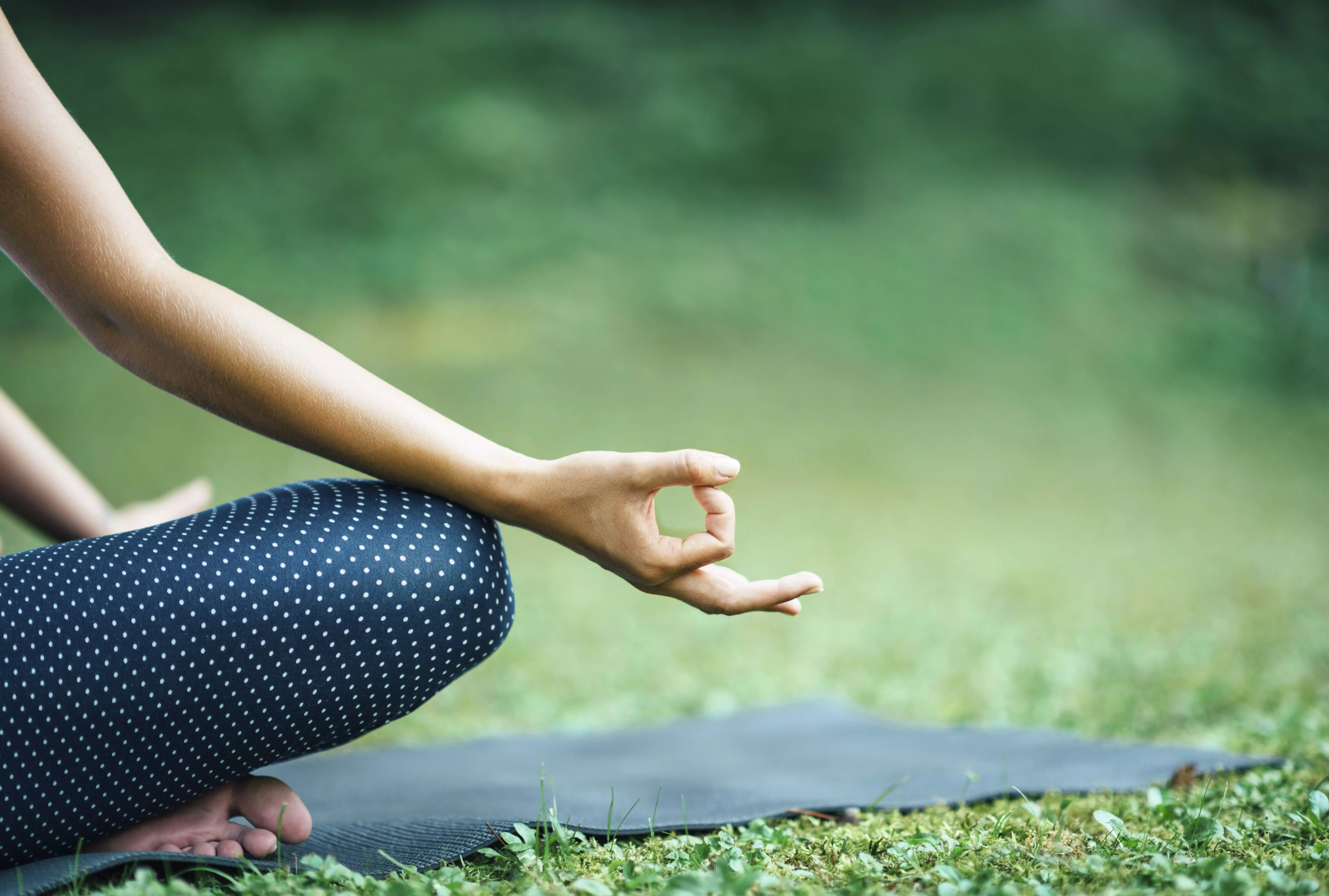 Seksioni i ulët i gruas që praktikon yoga në park