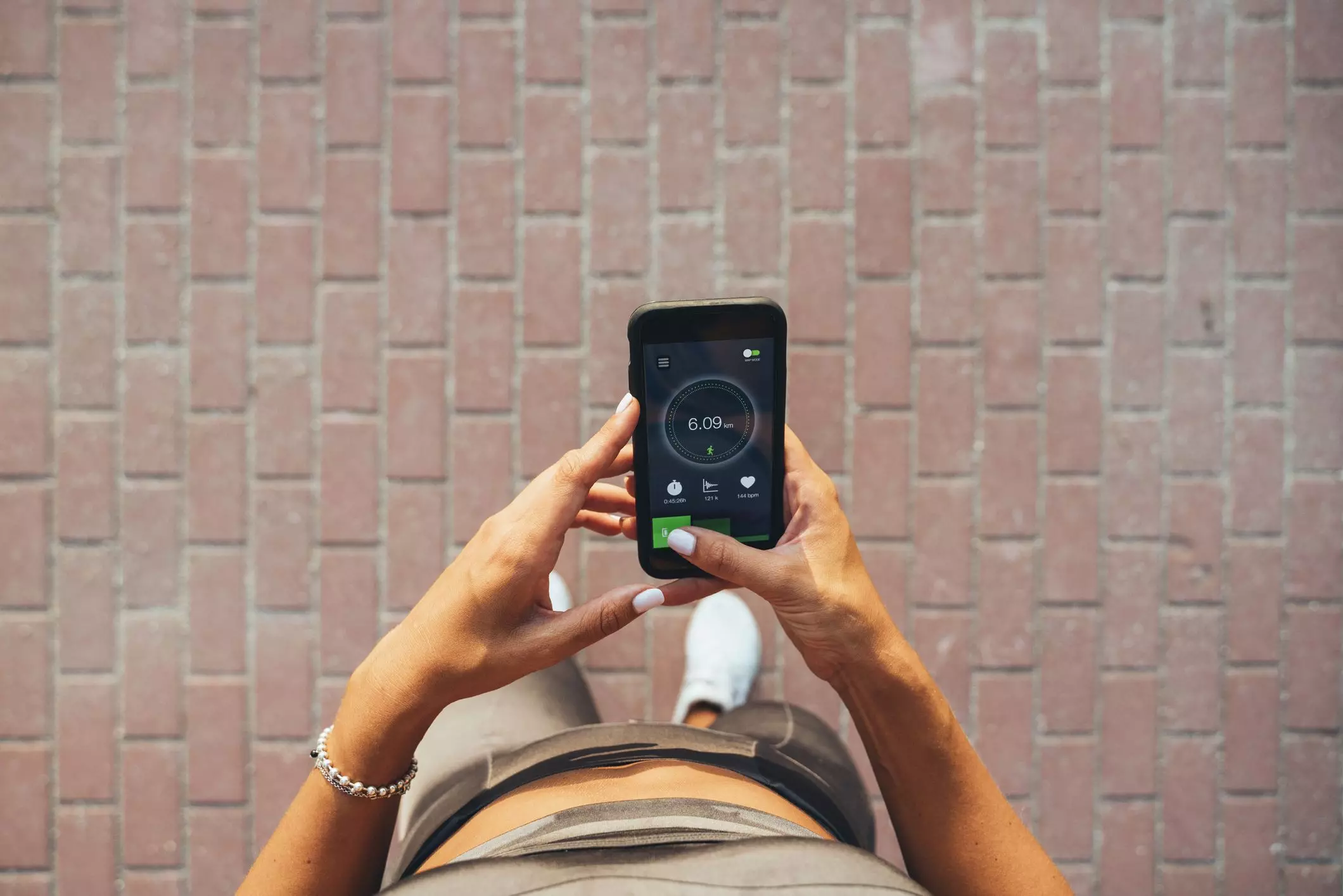 donna che guarda il telefono prima di iniziare a correre