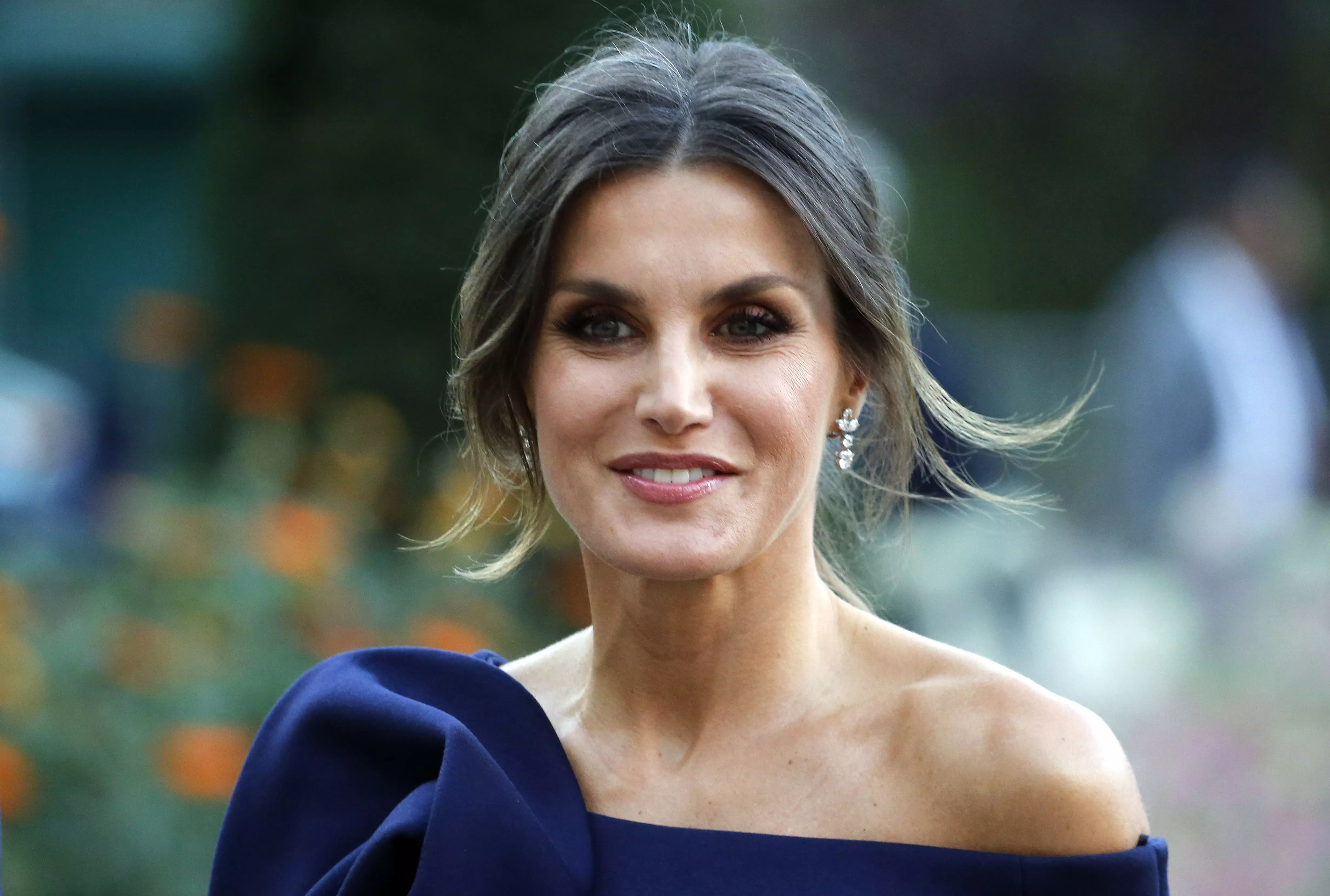 queen letizia posiert lächelnd auf einer ausstellung in paris