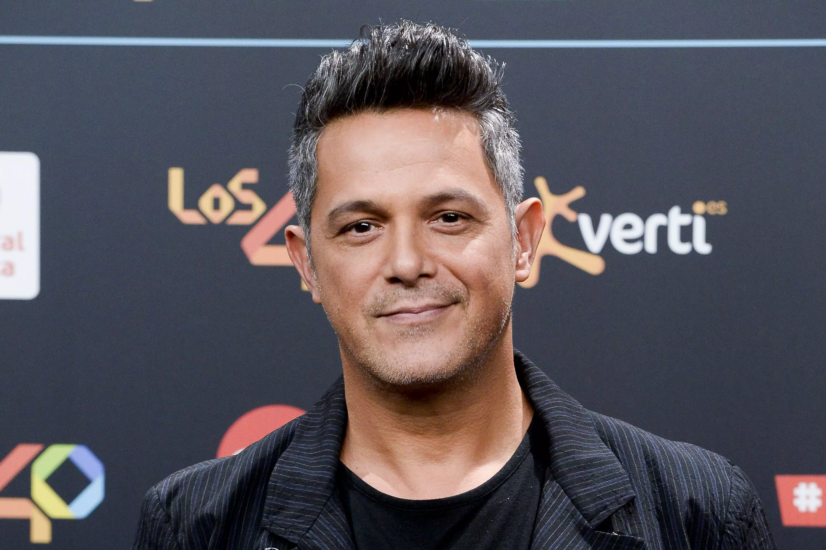 ο τραγουδιστής alejandro sanz ποζάρει σε ένα photocall χαμογελώντας