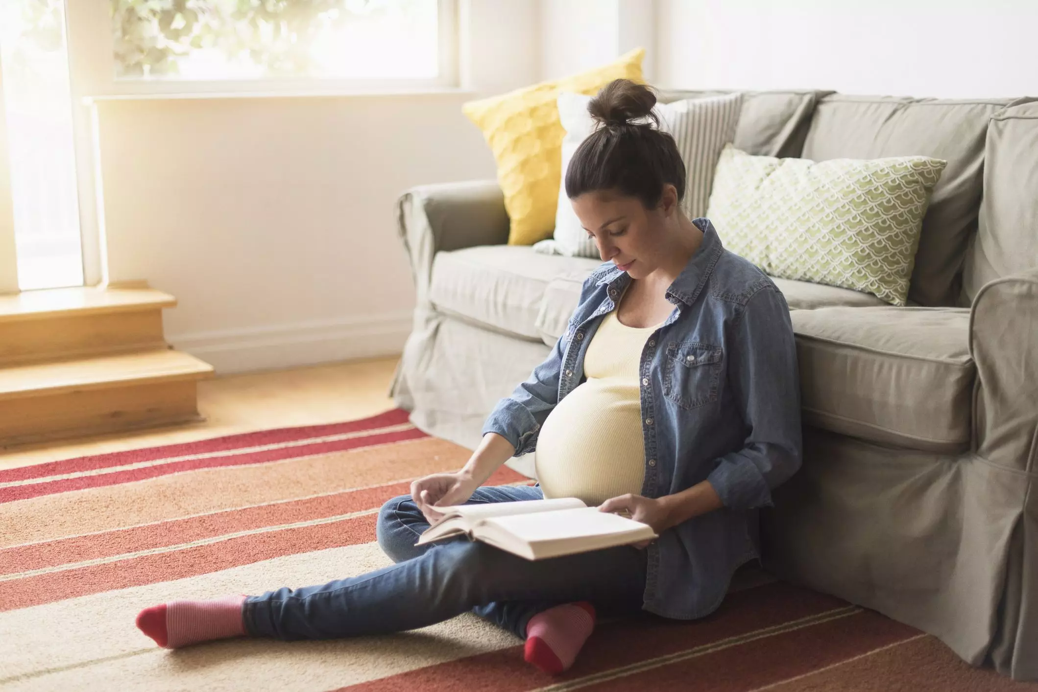 gravid kvinde sidder og læser en bog