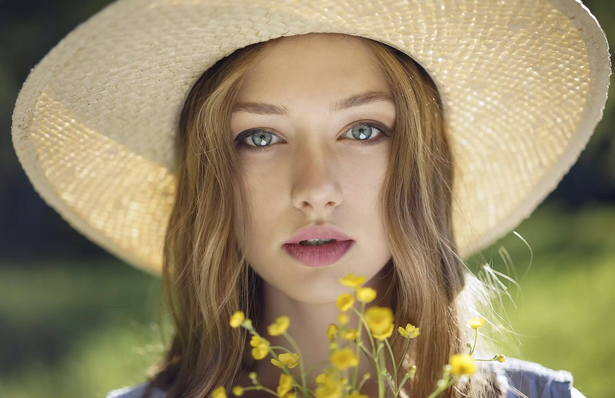 caucasian woman wearing hat holding wildflowers