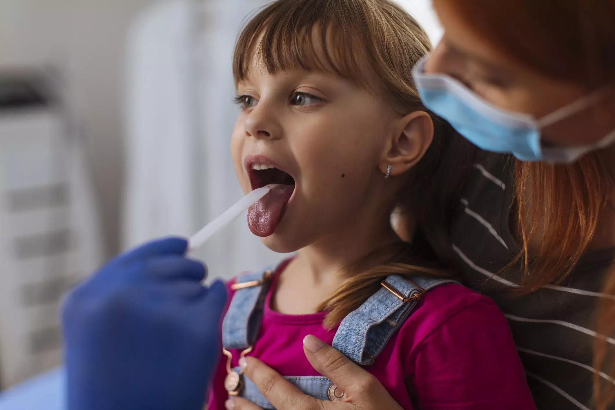 médico examinando a gorxa dunha nena