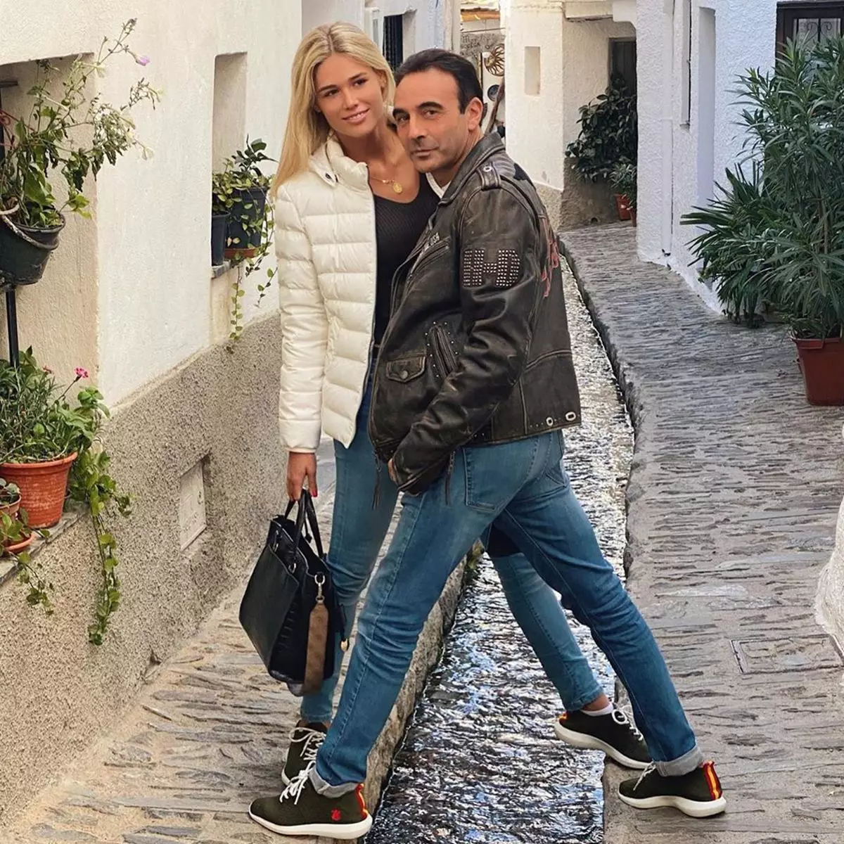 enrique ponce en ana soria posearje tegearre, mei deselde sneakers, yn in geplaveide steegje