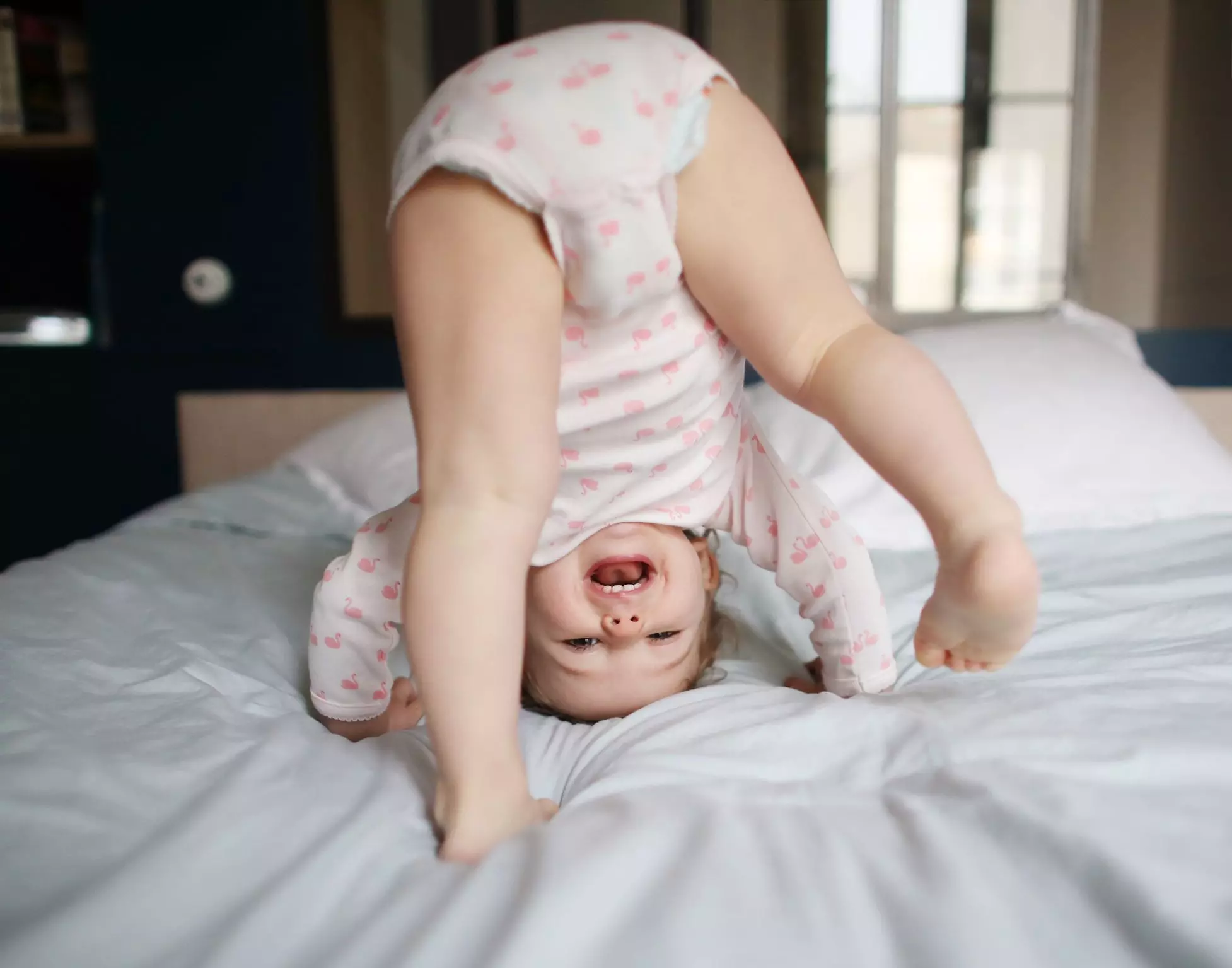 ベッドで遊ぶ女の赤ちゃん