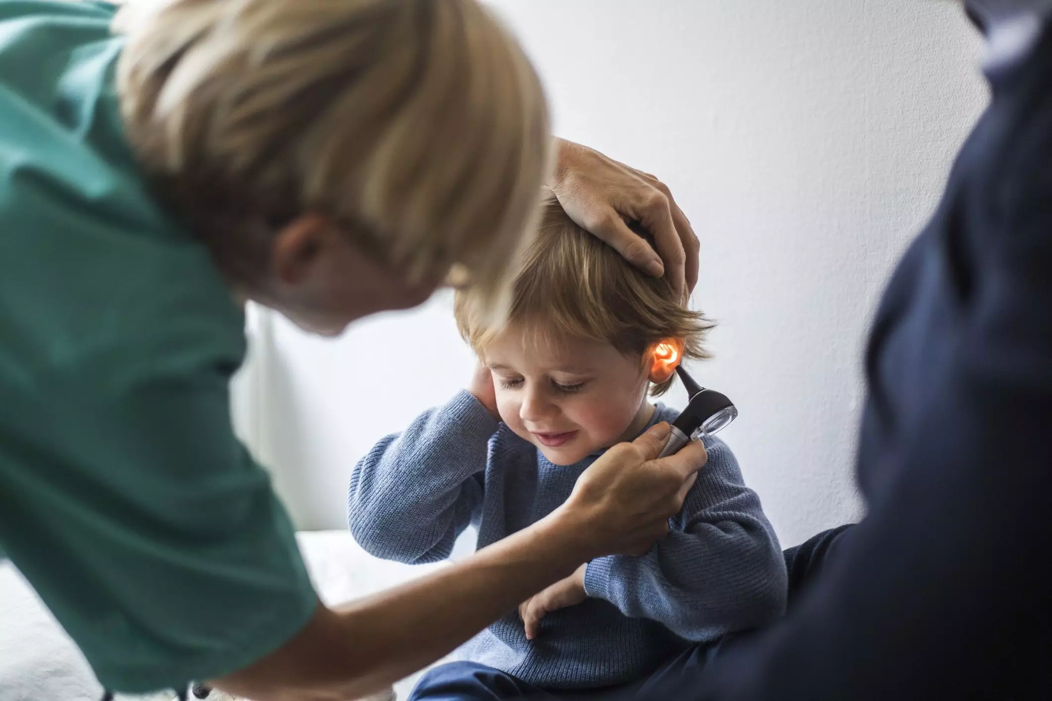 pediatras žiūri į vaiko ausį