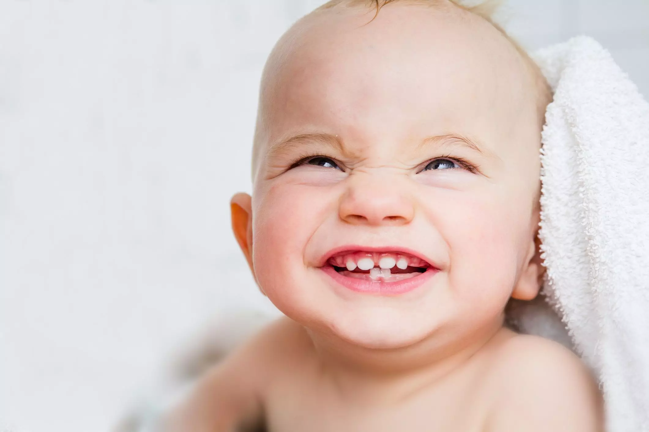 bebê mostrando seus primeiros dentes de leite