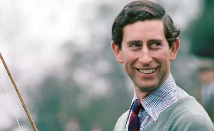 prince charles smiling with a fishing rod